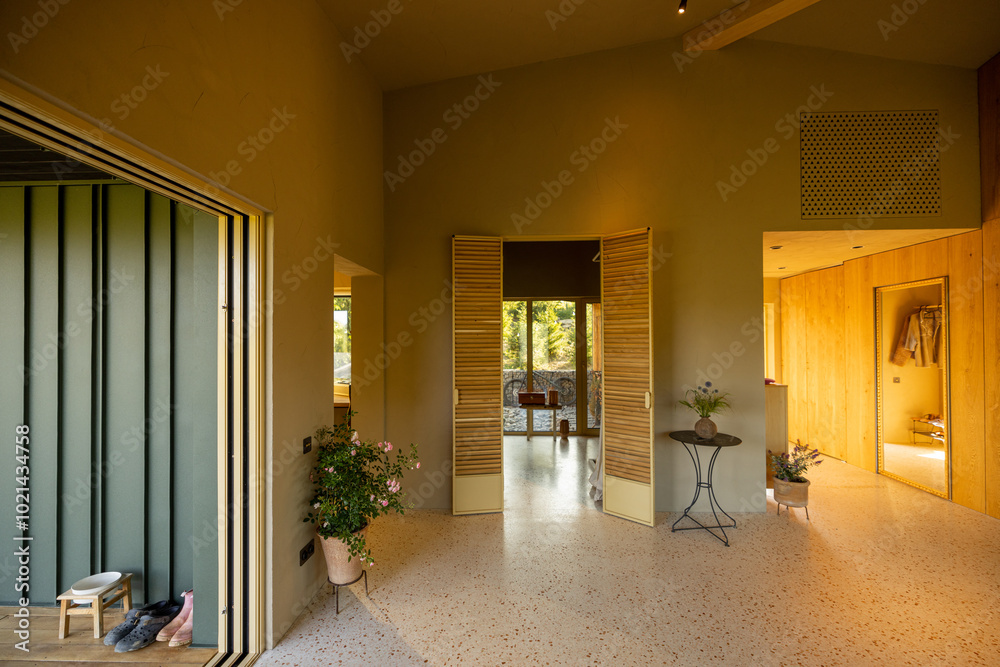 A bright and warm interior hallway featuring wooden shutters and ...