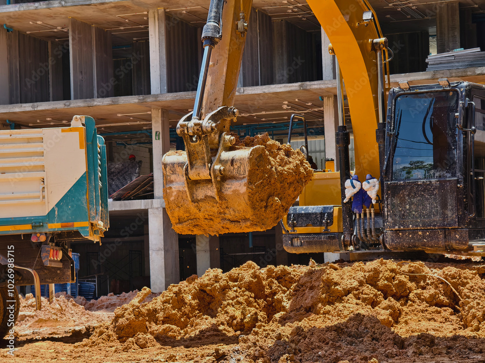 Excavator loads ground into a dump truck at a construction site Stock ...
