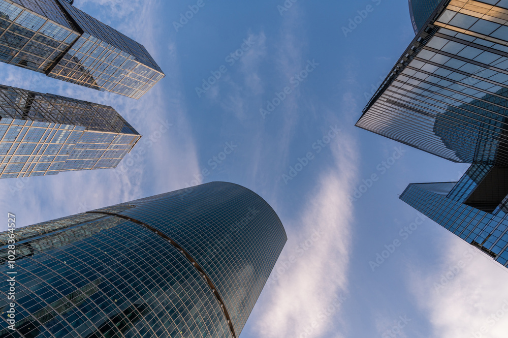 Angled view of modern skyscrapers in business district against blue sky ...