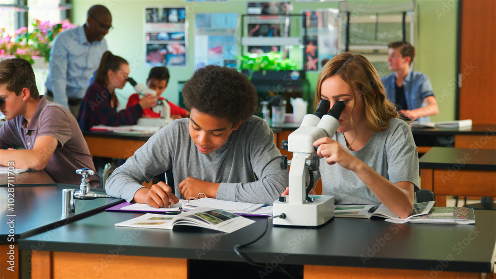 Male And Female High School Students Using Microscope In Biology Class ...