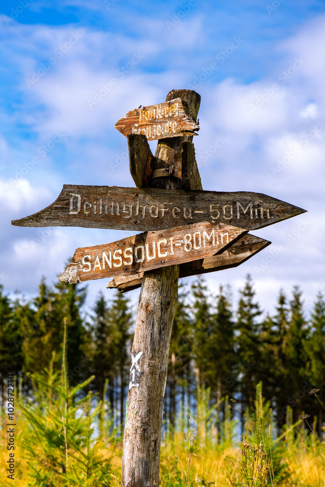 Weathered old signpost with wooden arrows at a crossroads of hiking ...