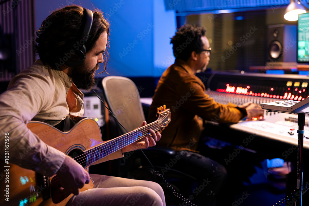 Musician composing new tracks on his electro acoustic guitar, playing ...