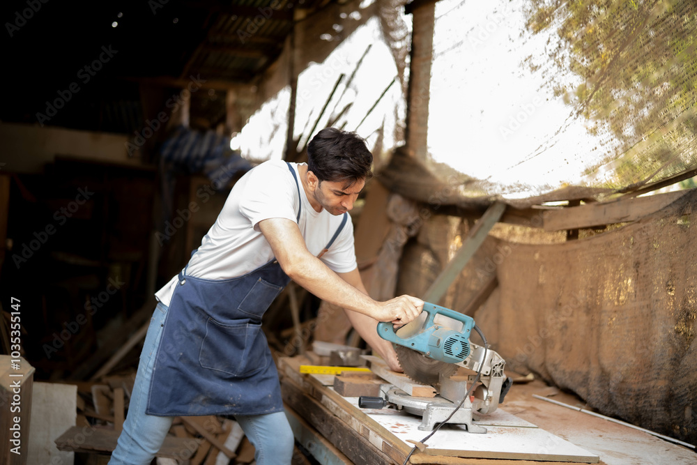 Carpenter man worker, using cutting machine cut peice of wood with ...