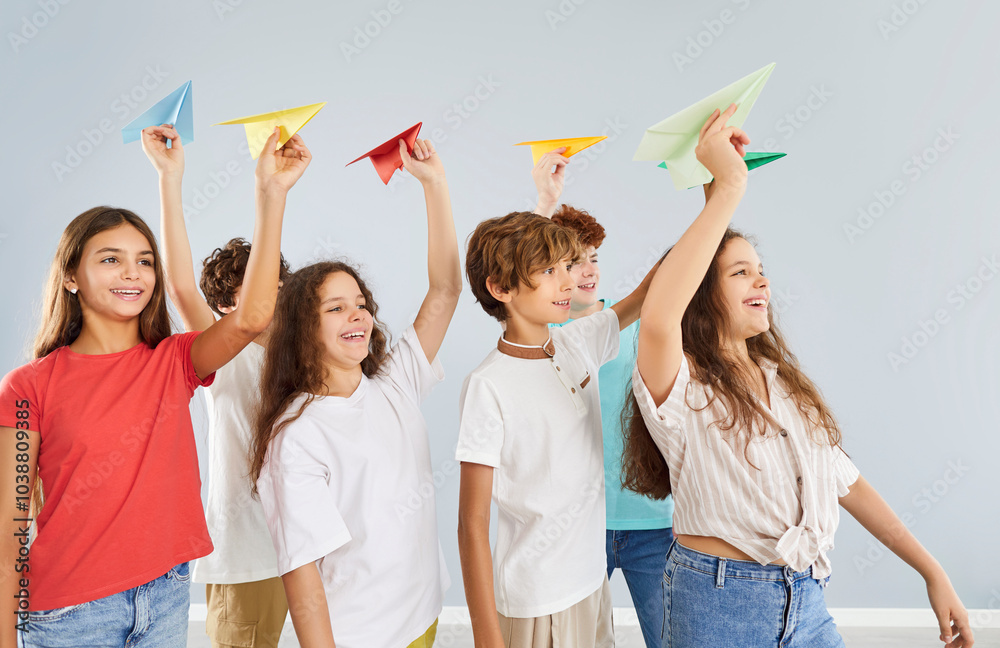 Team of happy children launching colorful paper airplanes together ...
