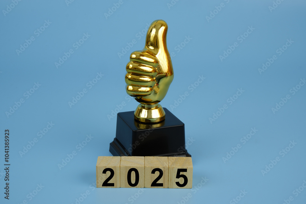 Gold champion thumbs up trophy cup and cubes with numbers 2025 on blue ...