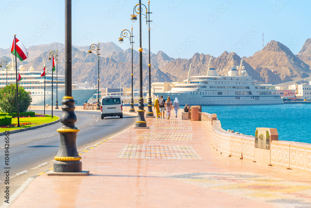 Tourists and local Omanis walking along the waterfront Mutrah Corniche ...