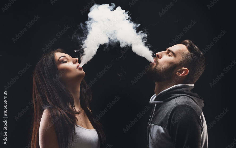 Couple vaping. Young man and woman blowing smoke to join it in one ...