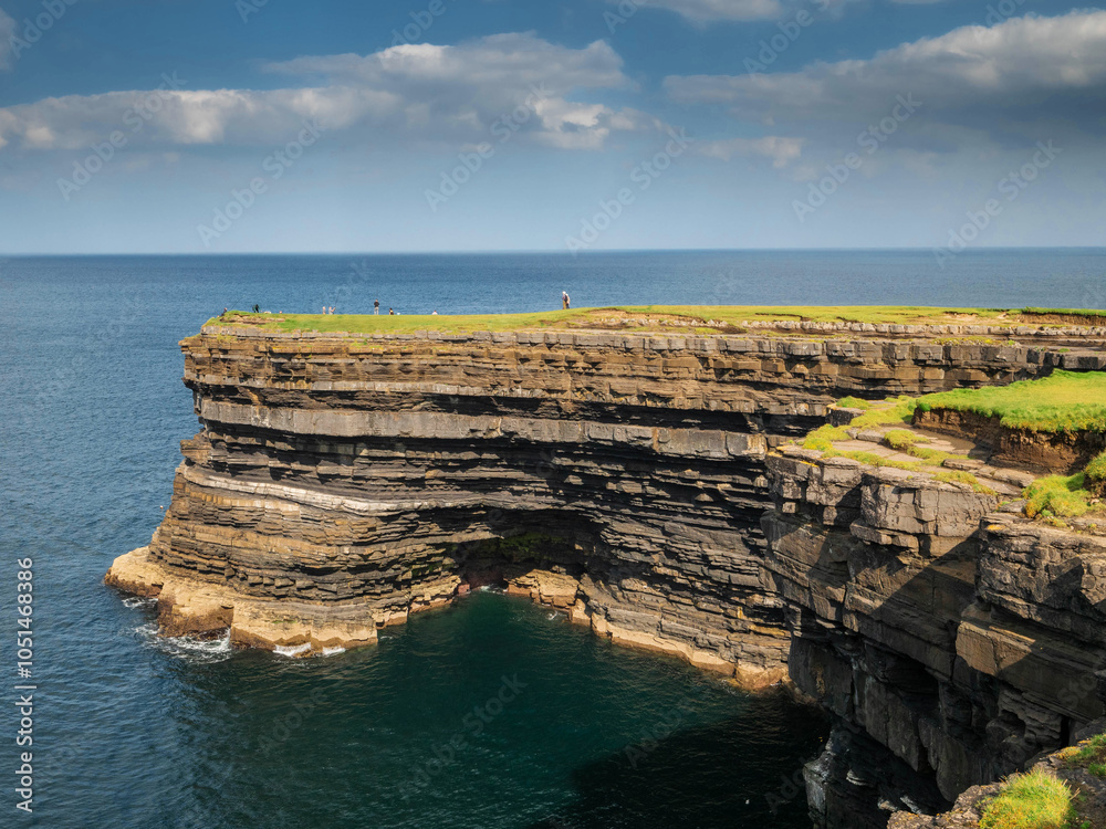 Rough stone coast line with cliff and blue ocean and blue sky ...