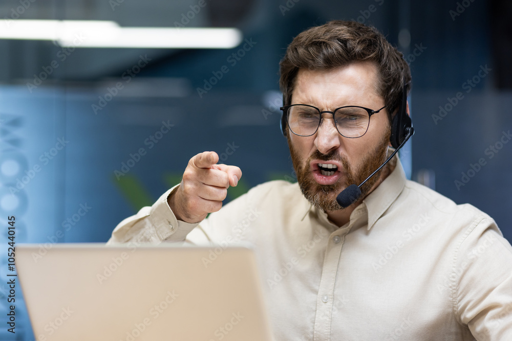Close-up photo of young angry man in headset sitting in office at ...