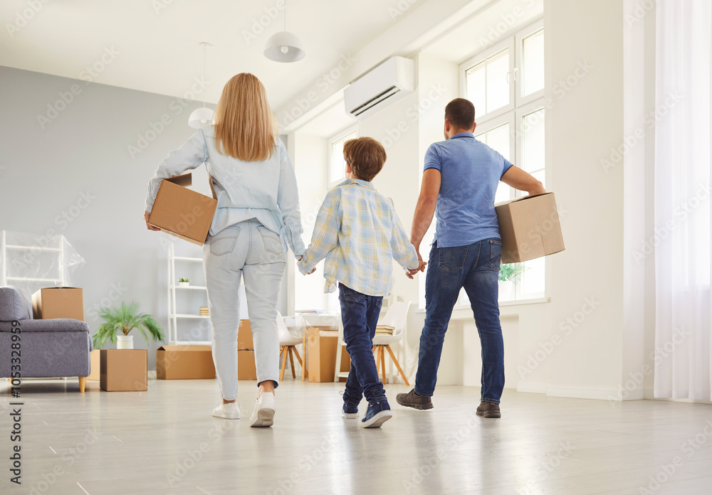 Backside view of a parents and son arrive at new house together ...