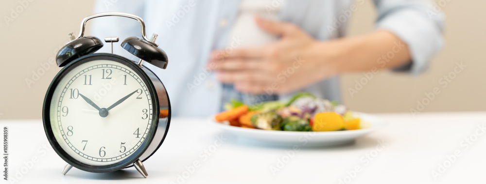 Intermittent fasting concept, Close-up on clock and people feeling ...