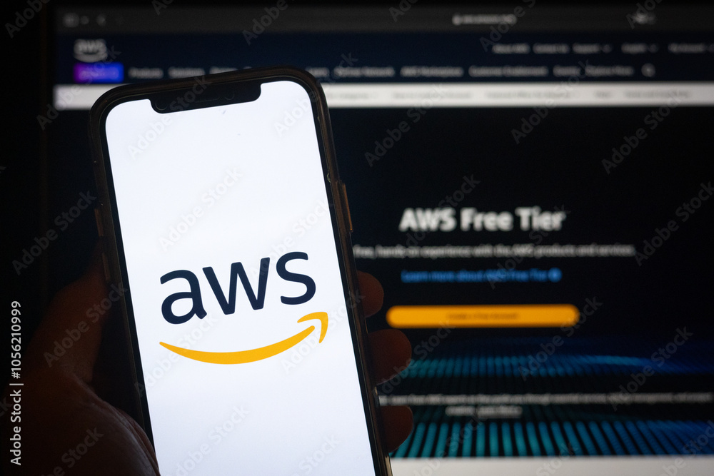 Silhouette of Hand Holding Phone with AWS (AMZN) Logo in Front of AWS ...