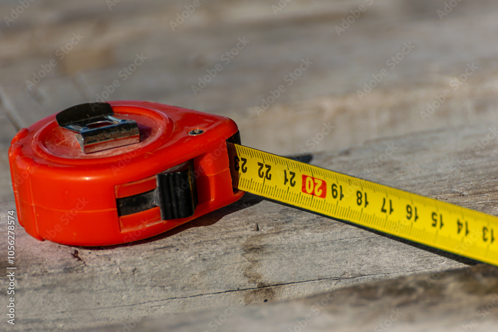 red and yellow construction tape measure, detail of a rolling meter or ...