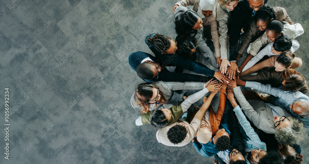 Diverse business team uniting with hands together in a show of teamwork ...