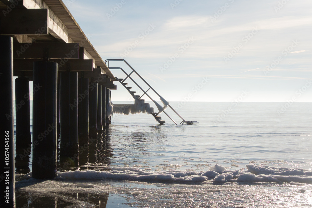 Frozen stairs with snow from the pier to the sea during winter on the ...