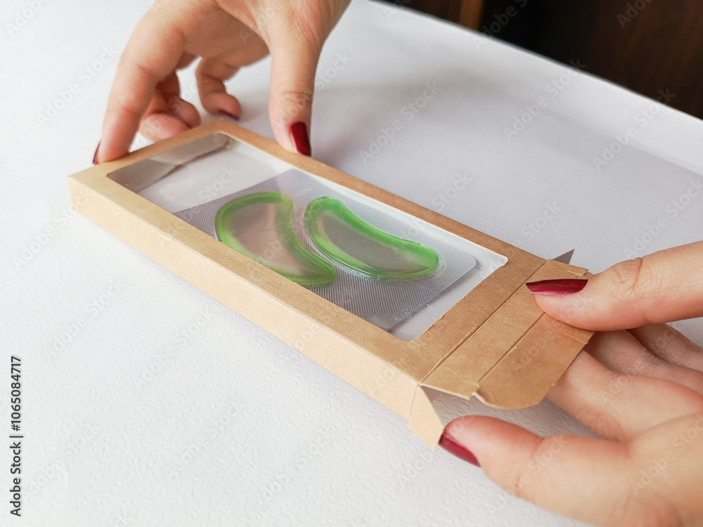 Hand packs eye patches in cardboard brown gift box with transparent ...