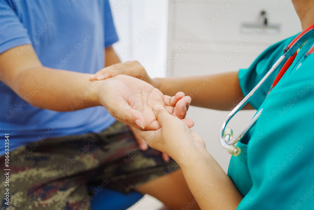 A female doctor sits a hospital desk,examining a sick male patient with ...