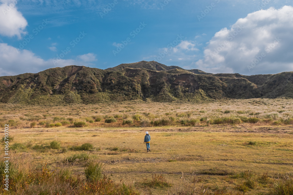 Woman standing in the green lanscape with mountain Aso background ...