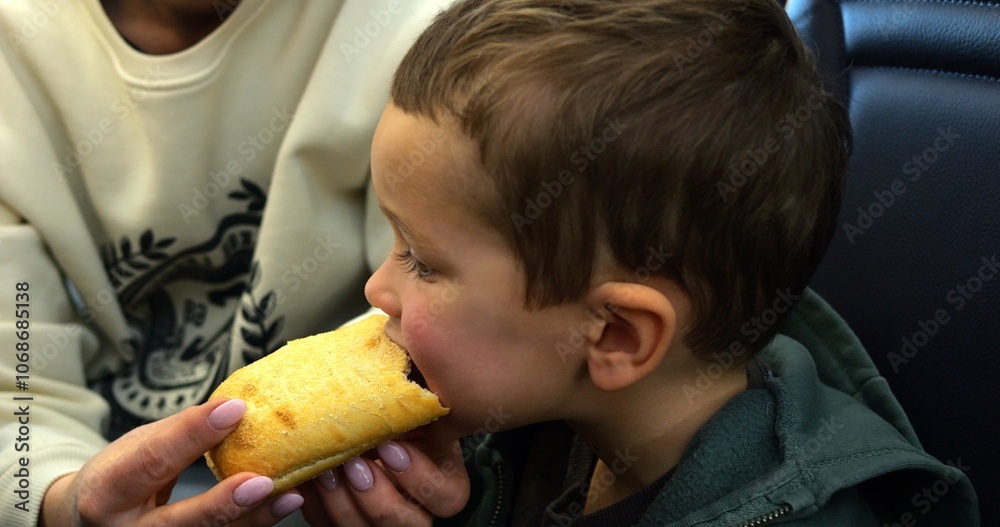 Toddler child bites piece of stuffed pie and nods head to mother riding ...
