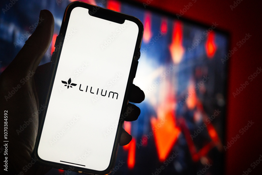 Hand Holding Phone with Lilium (LILM) Logo and Monitor in the ...