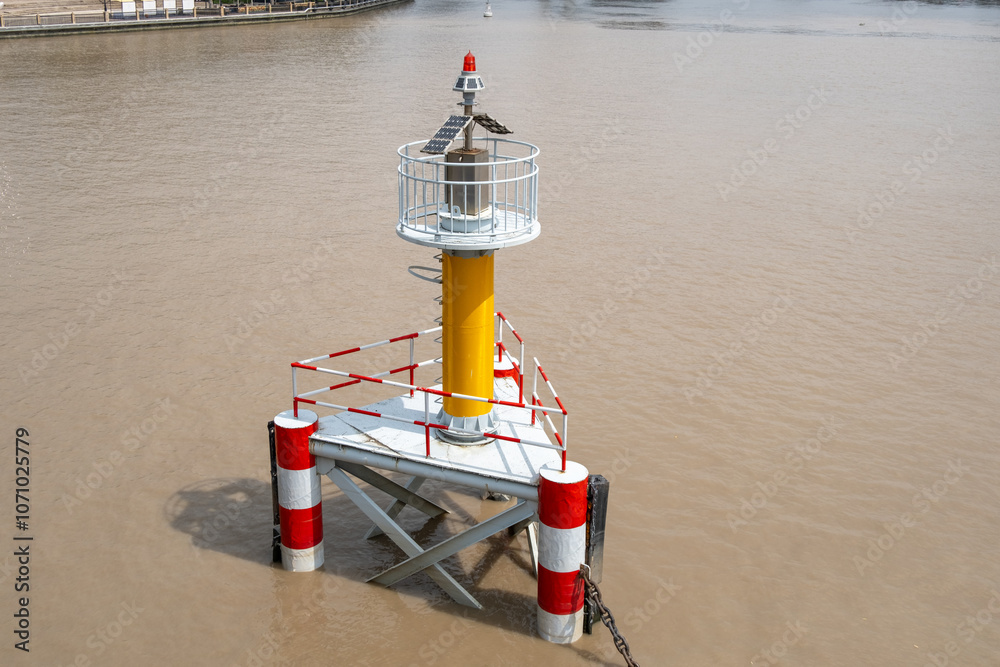 River navigation beacon with striped poles on a metal platform over ...