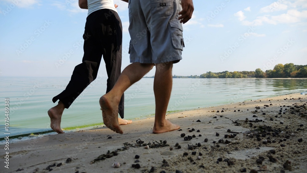 Bare feet of couple stepping together along beach at ocean background ...