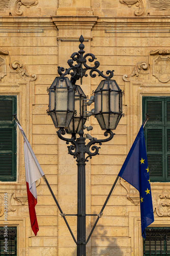 Valletta, Malta The EU and Malta flags hang from a lamppost in front of ...