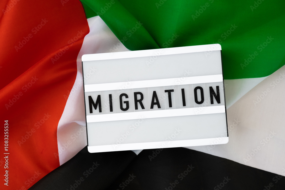 Message MIGRATION on background of UAE flag made from silk. United Arab ...