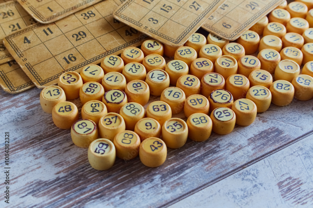 Old time-worn bingo cards and numbered game tokens lie on an old worn ...