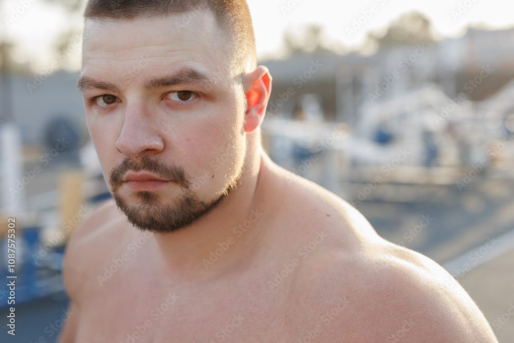 Yung handsome bodybuilding athlete poses against te basque ground of ...