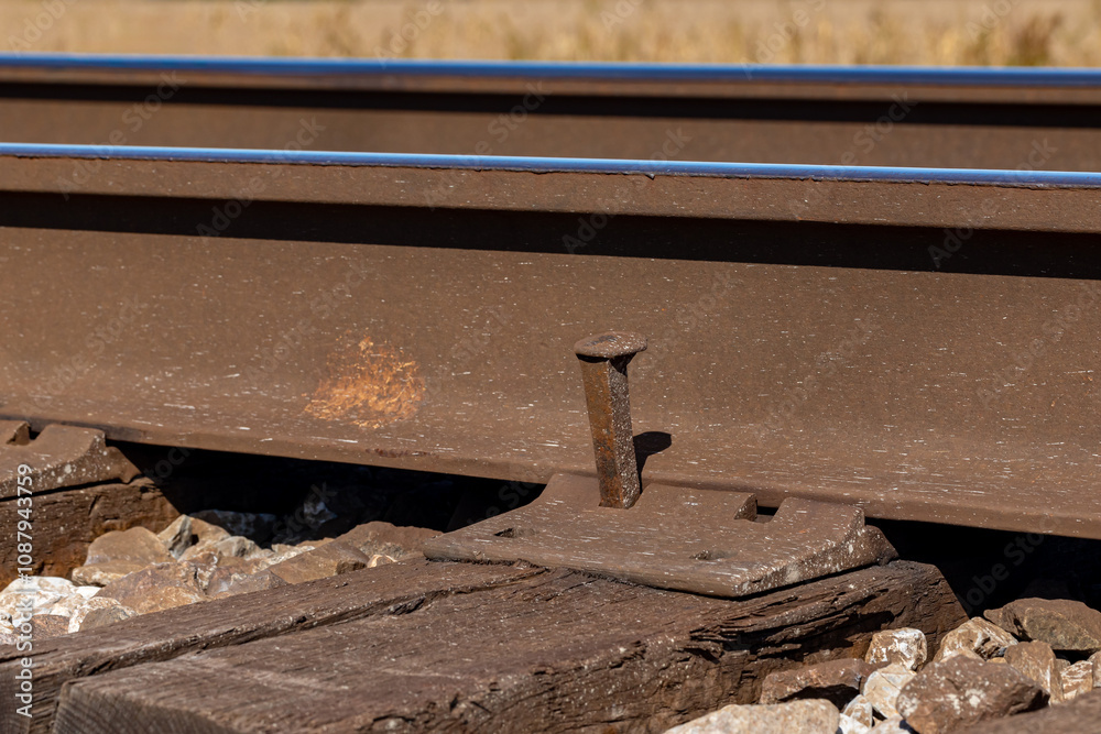 Railroad tracks with spike sticking up. Railway maintenance, track ...