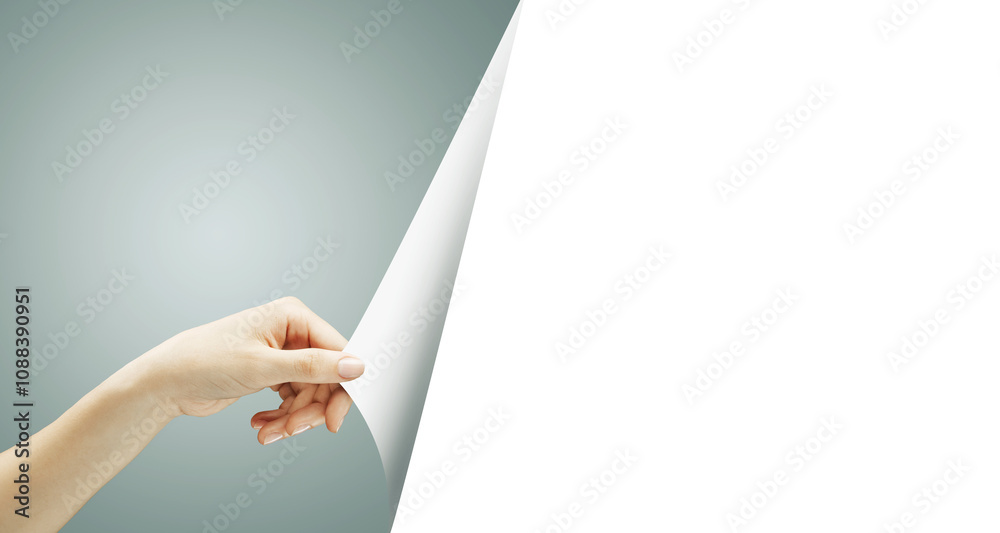 A hand is shown pulling back a paper corner, revealing a blank white ...