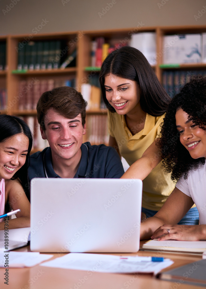 Vertical. Diverse group high school young students working together using and looking at laptop ...