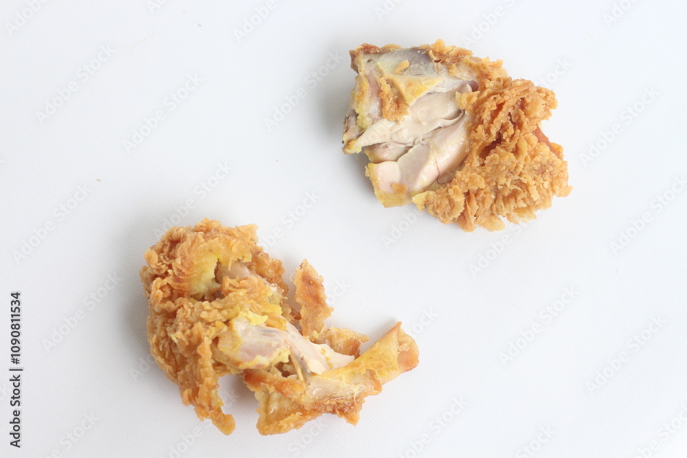 A piece of fried chicken is cut in half, revealing the meat inside ...