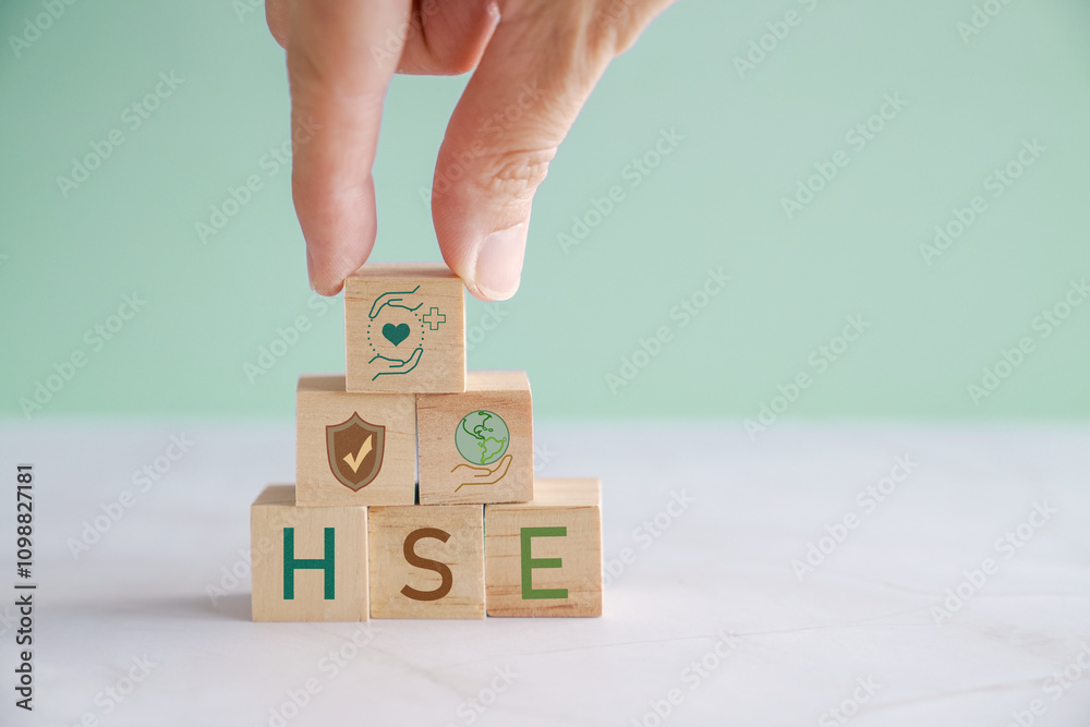 Hands holding wooden blocks with HSE and health, safety and environment ...