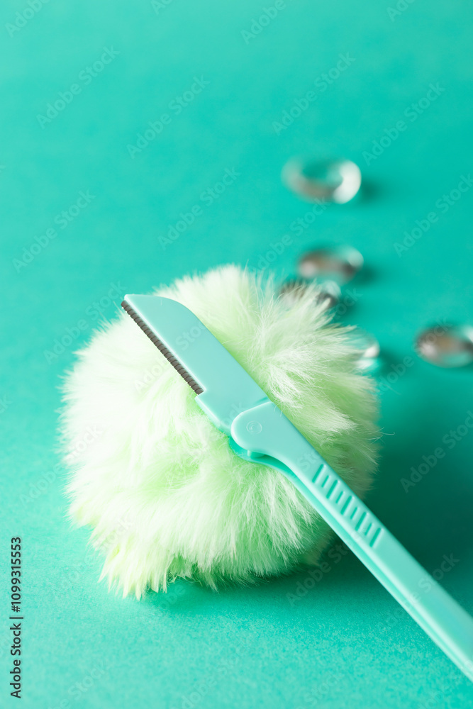 Pastel green facial razor on a fluffy, mint-colored ball at green ...