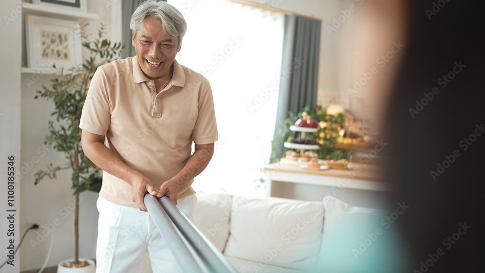 Elderly man playing a ball rolling game with his partner at home, practicing hand-eye ...