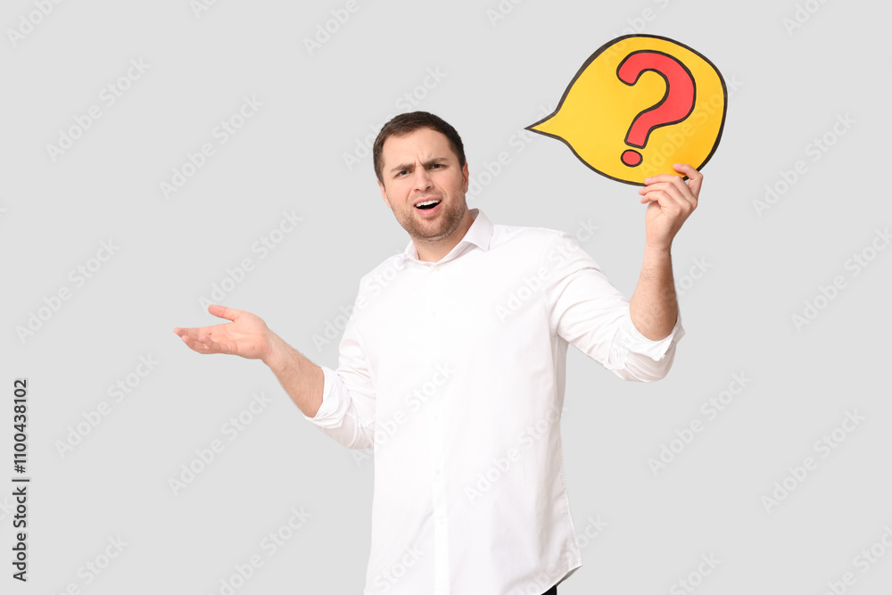 Confused young man with question mark on white background Stock Photo ...