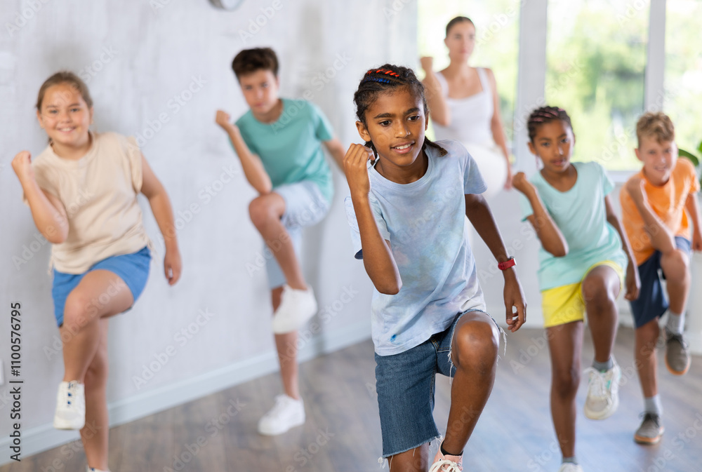 Active preteen boy practicing Hip-hop dance with other children and ...