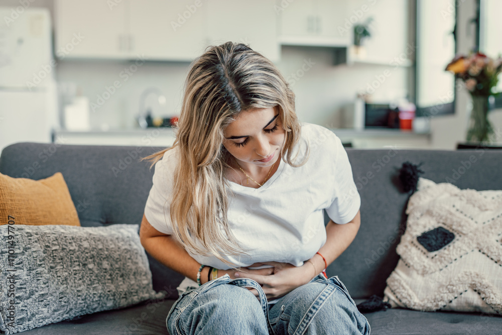 Sick young woman in pain holding belly stomach feeling hurt abdomen ache gastritis pancreatitis ...