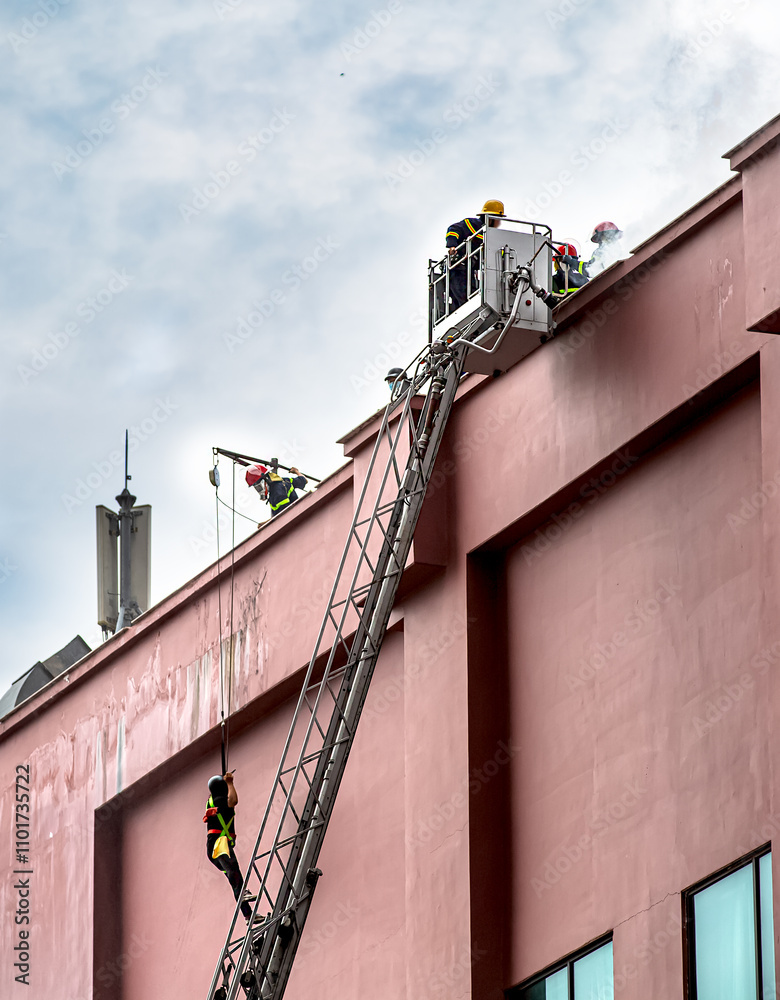 Side view of firefighters extinguish fire on the roof of a high-rise ...