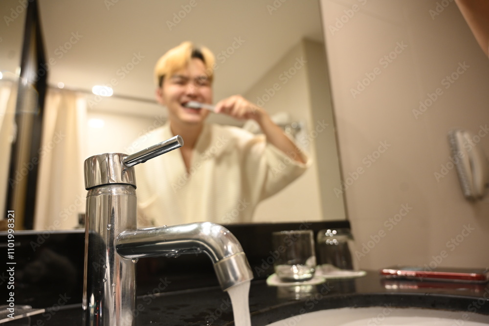 Close-up of a faucet left open while a man brushing his teeth, Campaign ...