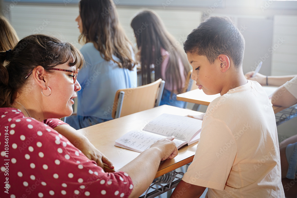 Young Teacher helping hispanic student boy to understand homework ...