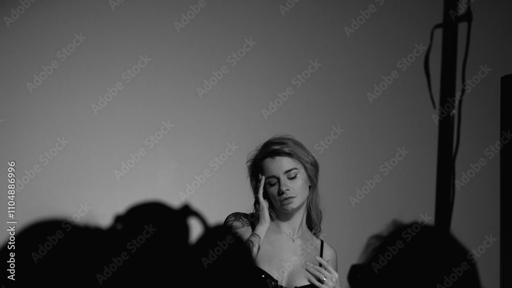 Blonde with a beautiful figure in a black patent leather bodysuit ...