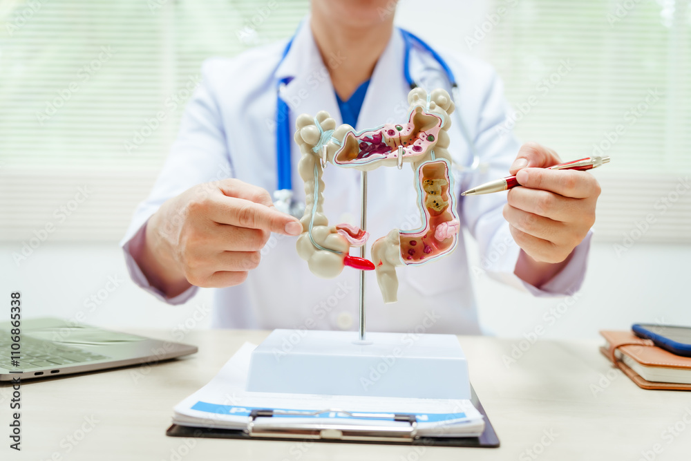 A male doctor wearing glasses sits at a desk, explaining an intestinal ...