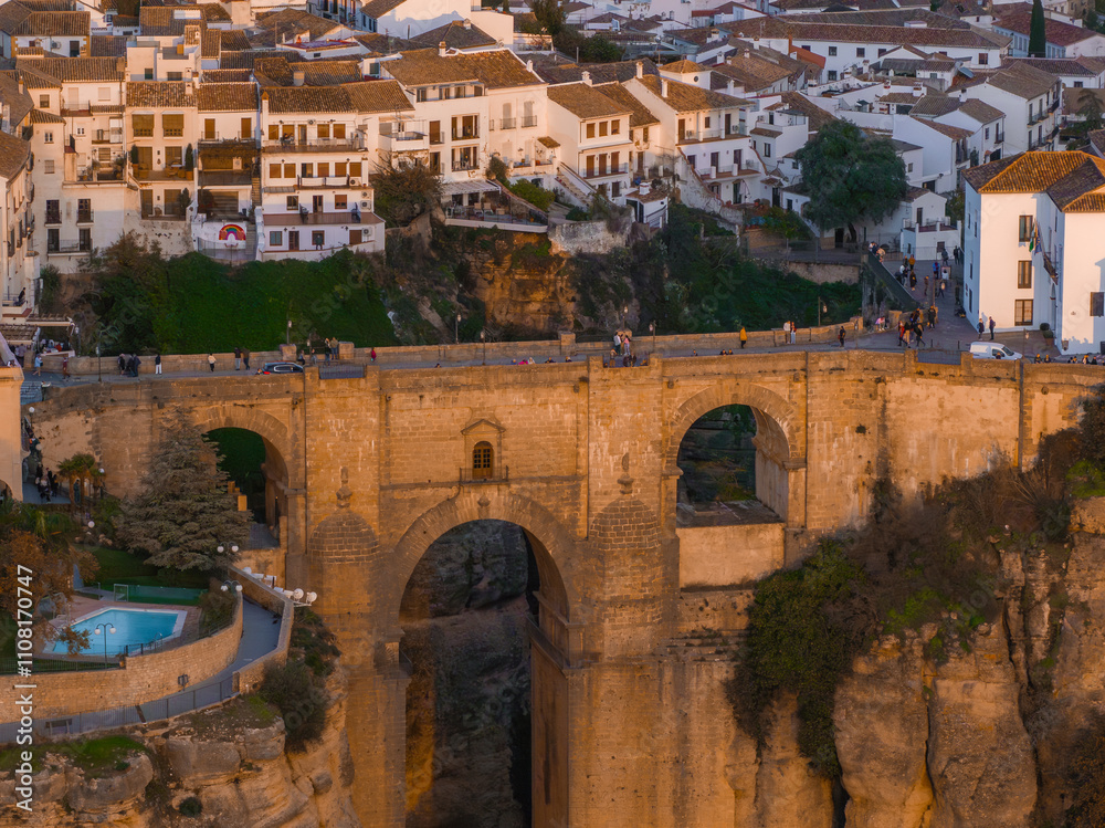 The image shows an aerial view of Puente Nuevo in Ronda, Spain, with whitewashed buildings on ...