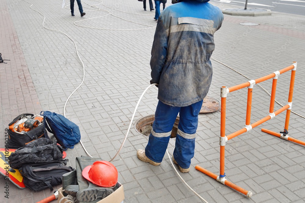 Professional utility worker engaged in underground fiber optic cable ...