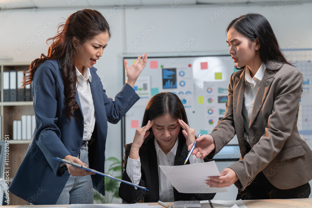 Two angry businesswomen arguing and blaming a stressed colleague with a ...