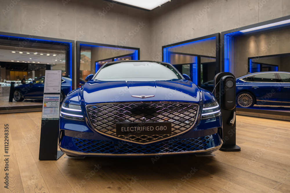 blue electric vehicle Genesis GV80 in stylish dealership, powerful ...