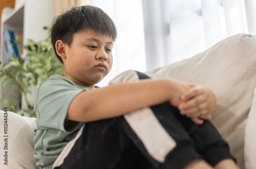 Young boy sitting with thoughtful expression, child feeling emotional ...
